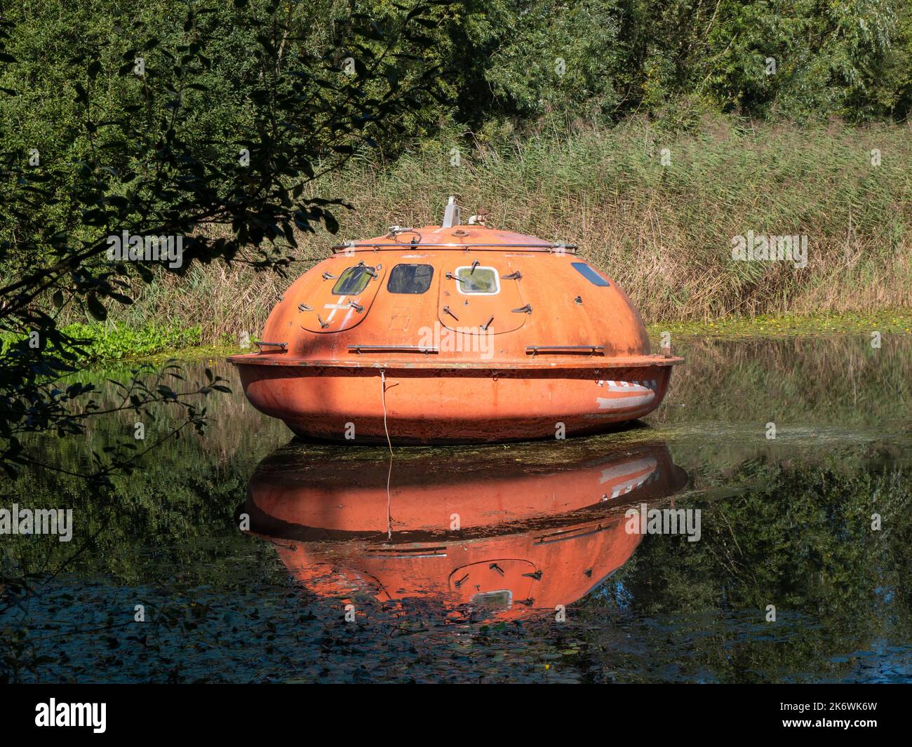 An orange rescue capsule or fully lockable lifeboat on the water Stock ...