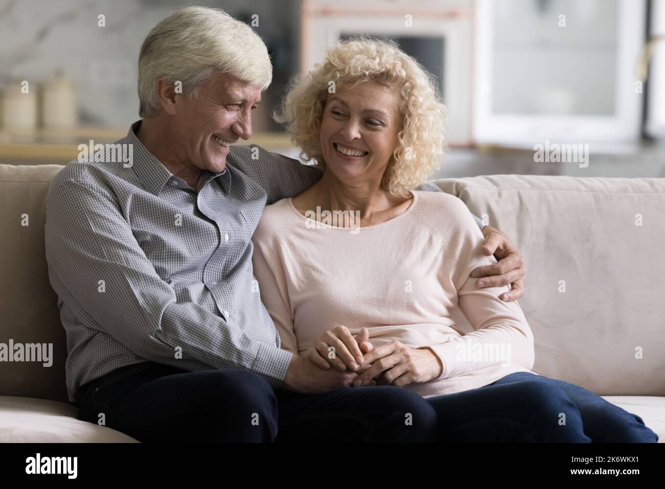 Attractive loving older couple talking seated on couch Stock Photo - Alamy