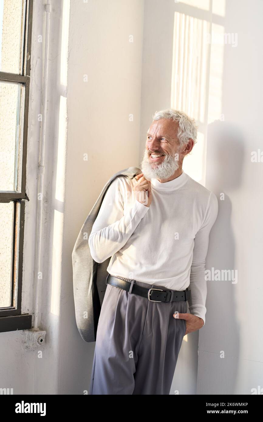 Smiling stylish senior older business man looking through window Stock ...