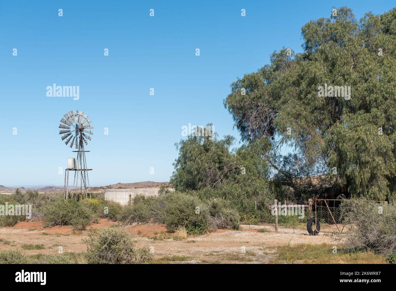 A windmill, watertank and concrete dam on the road between Loxton and ...