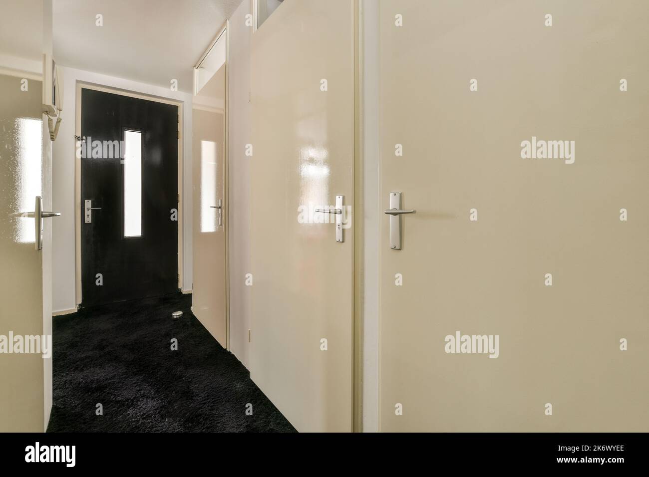 Light narrow hallway with many doors in white walls and glowing lamp ...