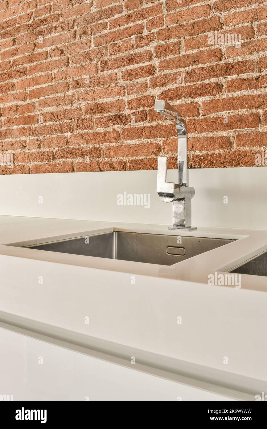 Shiny faucet installed on clean sink in modern kitchen at home Stock ...