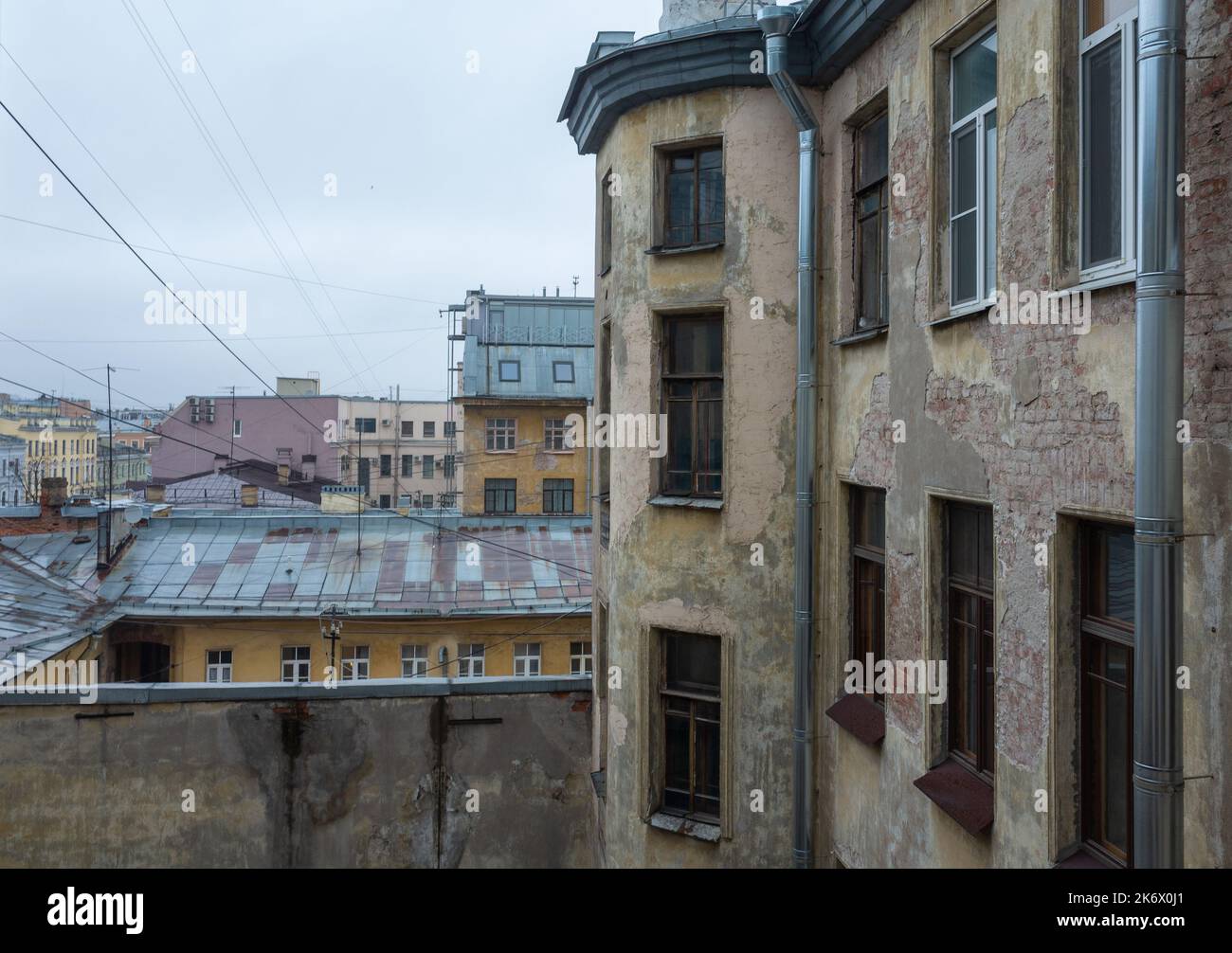 View of rusty roofs and peeling plaster on the wall of a 19th century ...
