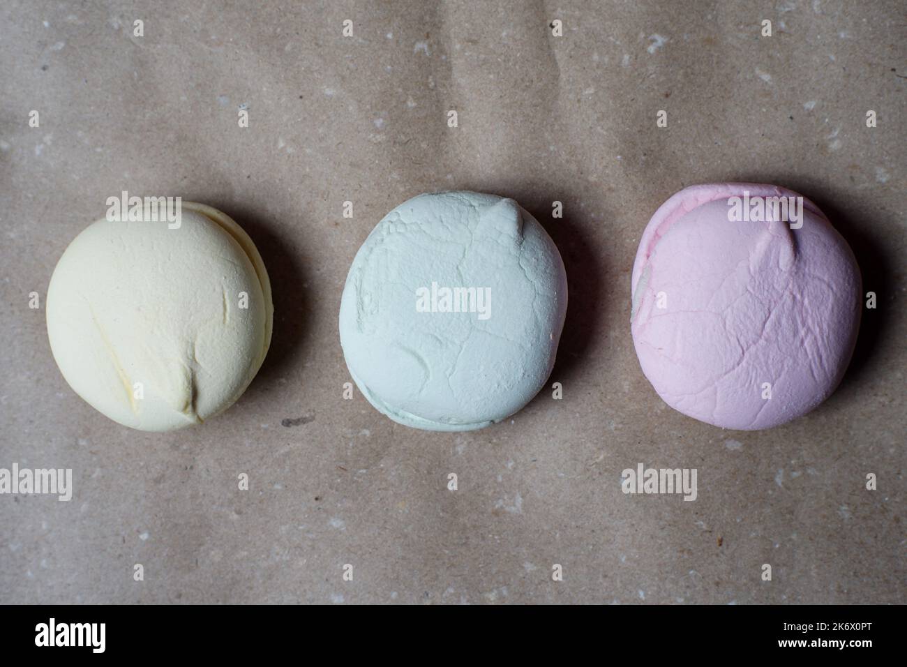 Three colorful handmade marshmallows on craft paper on the table Stock ...