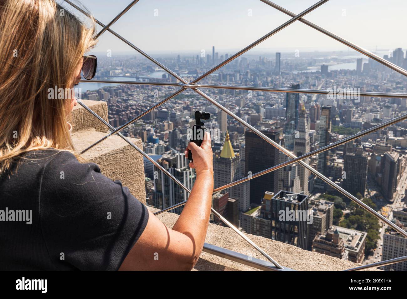 Woman filming view of Manhattan from Empire State Building. New York ...