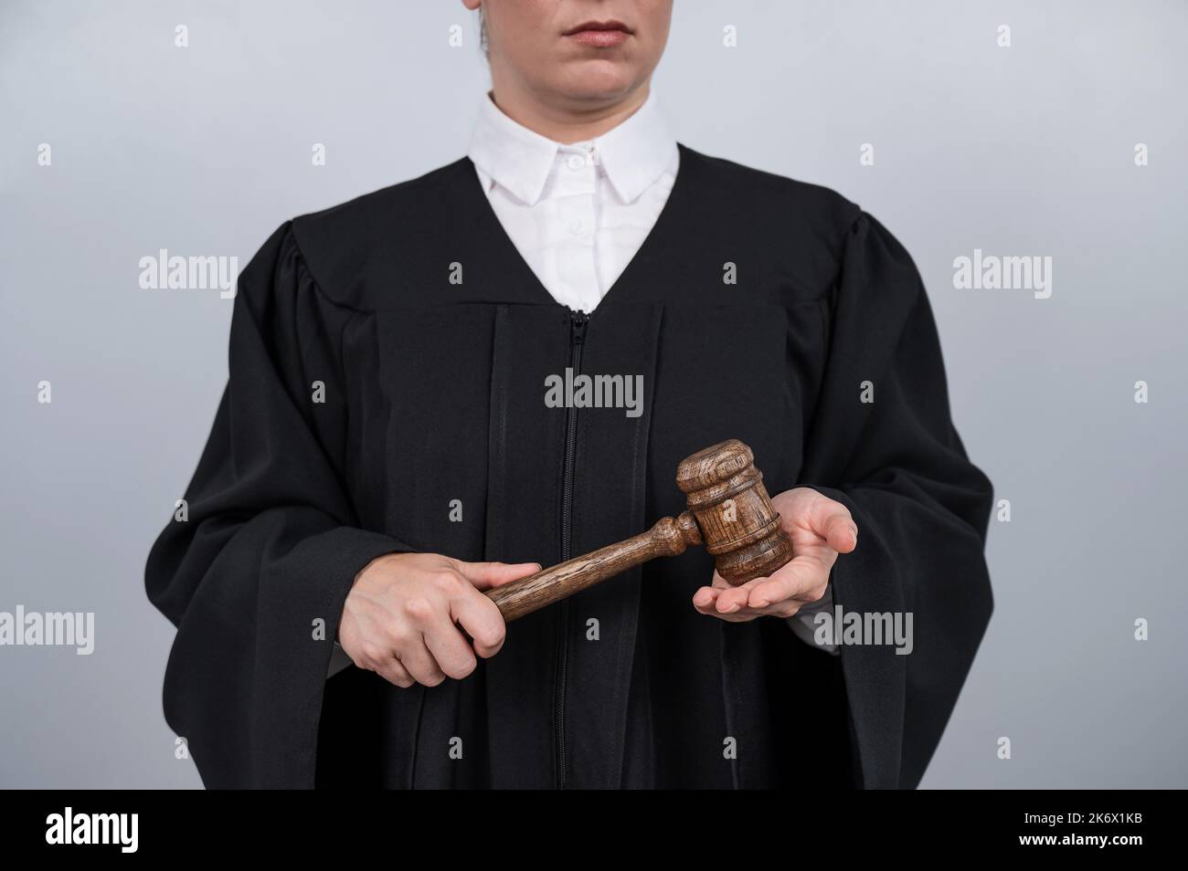 Faceless female judge in a robe holding a court gavel Stock Photo - Alamy
