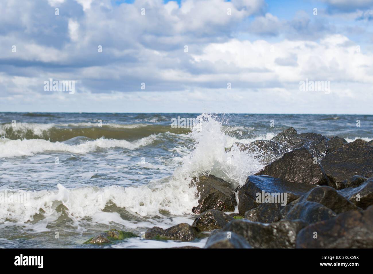 Wave hit the rock at beach, sea water splash up to the sky with ...