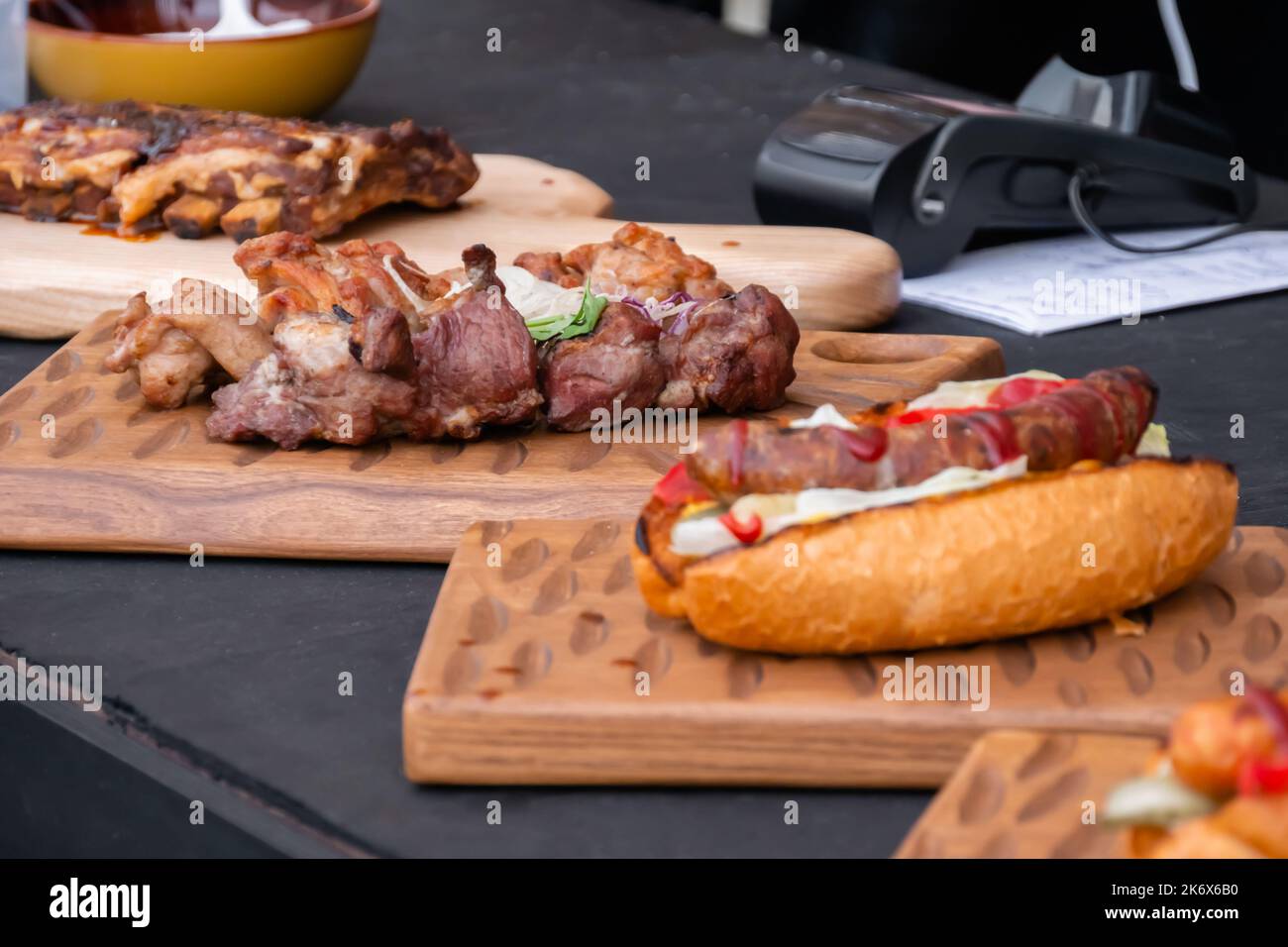 Hot dog, beef ribs and shish kebab on wooden board at street food ...