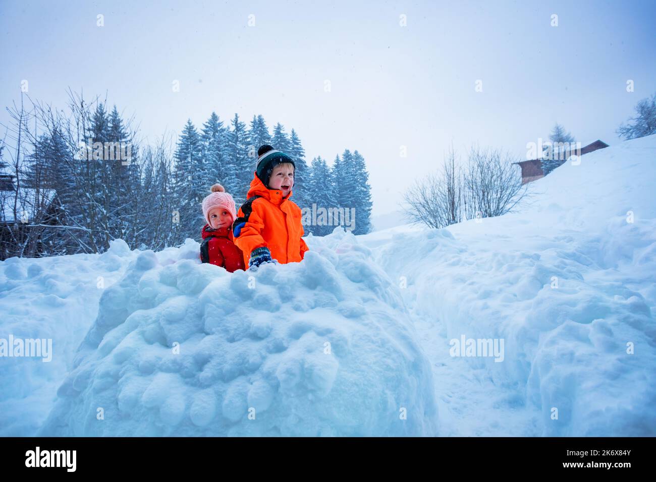Two little children play snowball in the snow fortress Stock Photo - Alamy