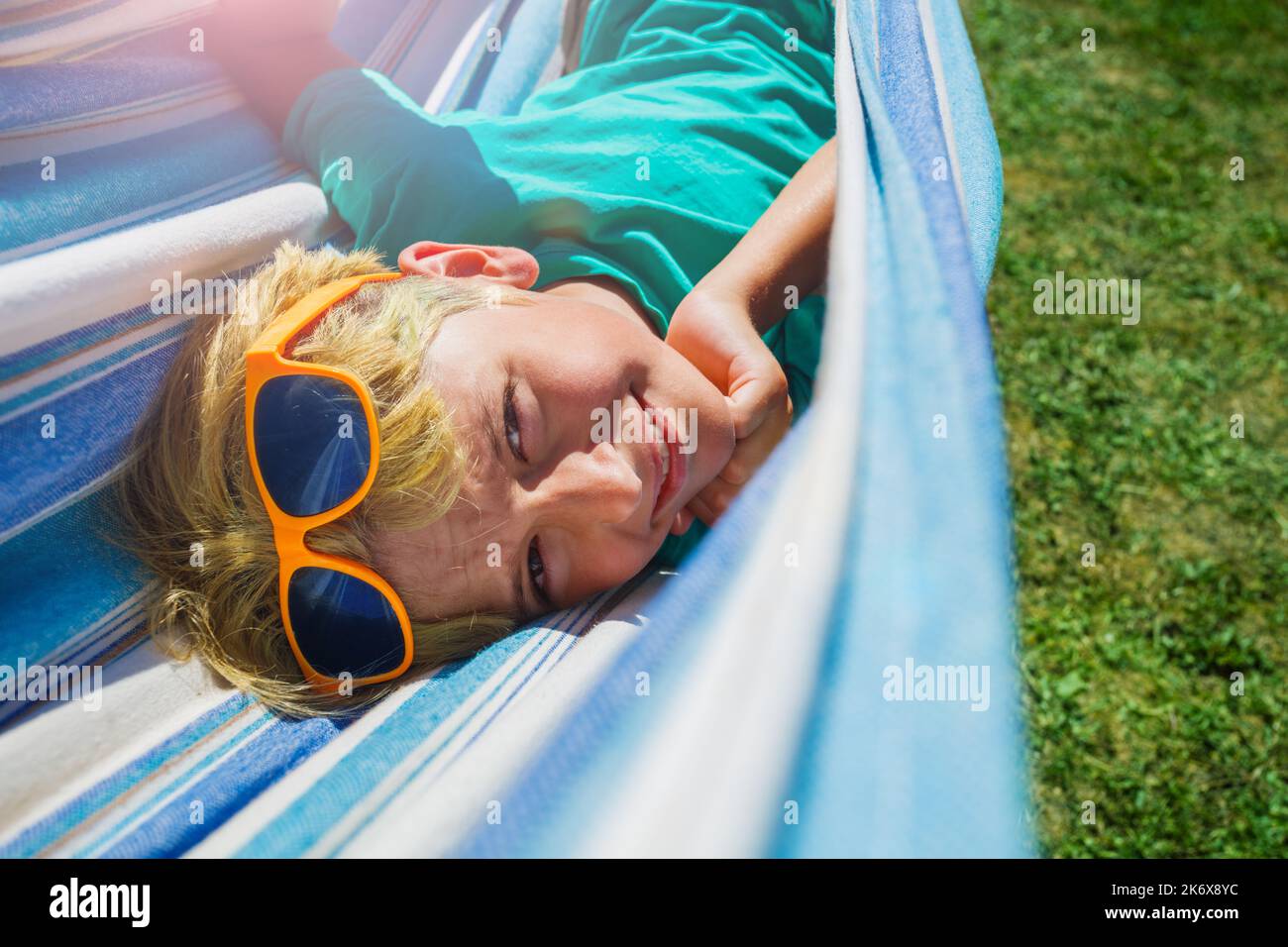 Boy lay in hammock close portrait turning head up and smile Stock Photo ...
