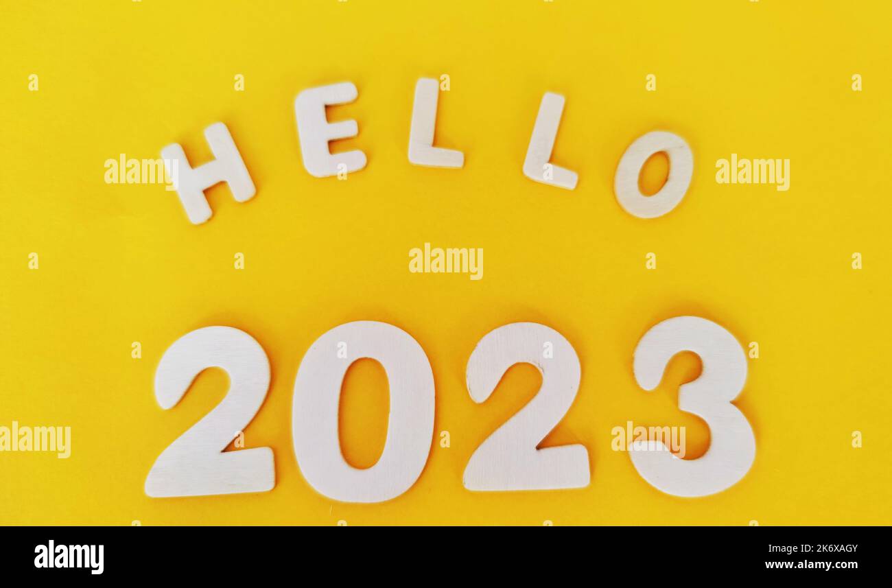 HELLO 2023. wooden letters and numbers with text on a YELLOW background ...