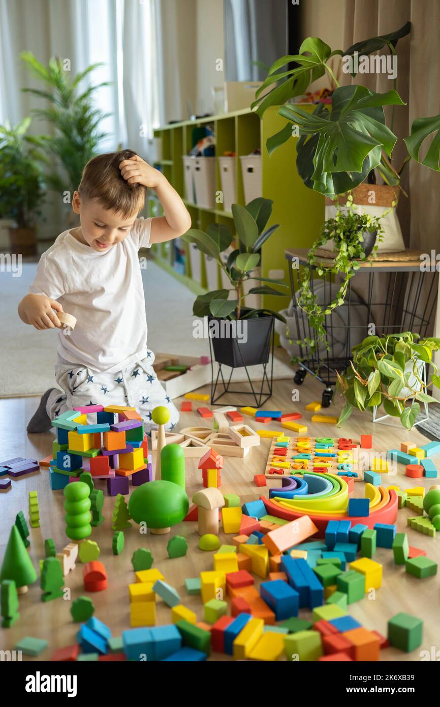 Confident male kid building fortress tower architecture and forest with ...
