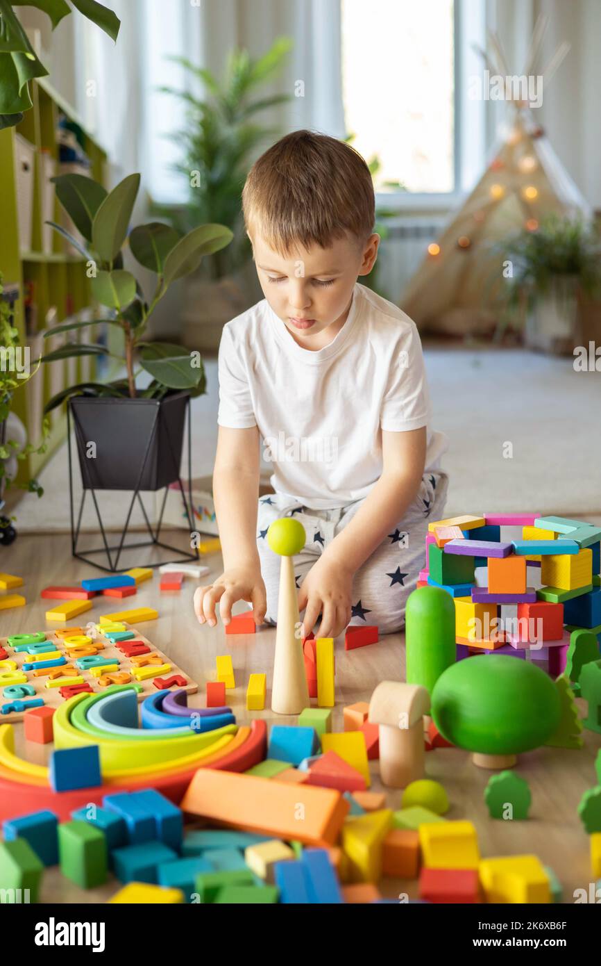 Confident male kid building fortress tower architecture and forest with ...