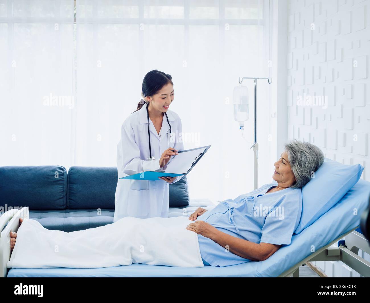 Young Asian female doctors visit senior woman patient in bed ...