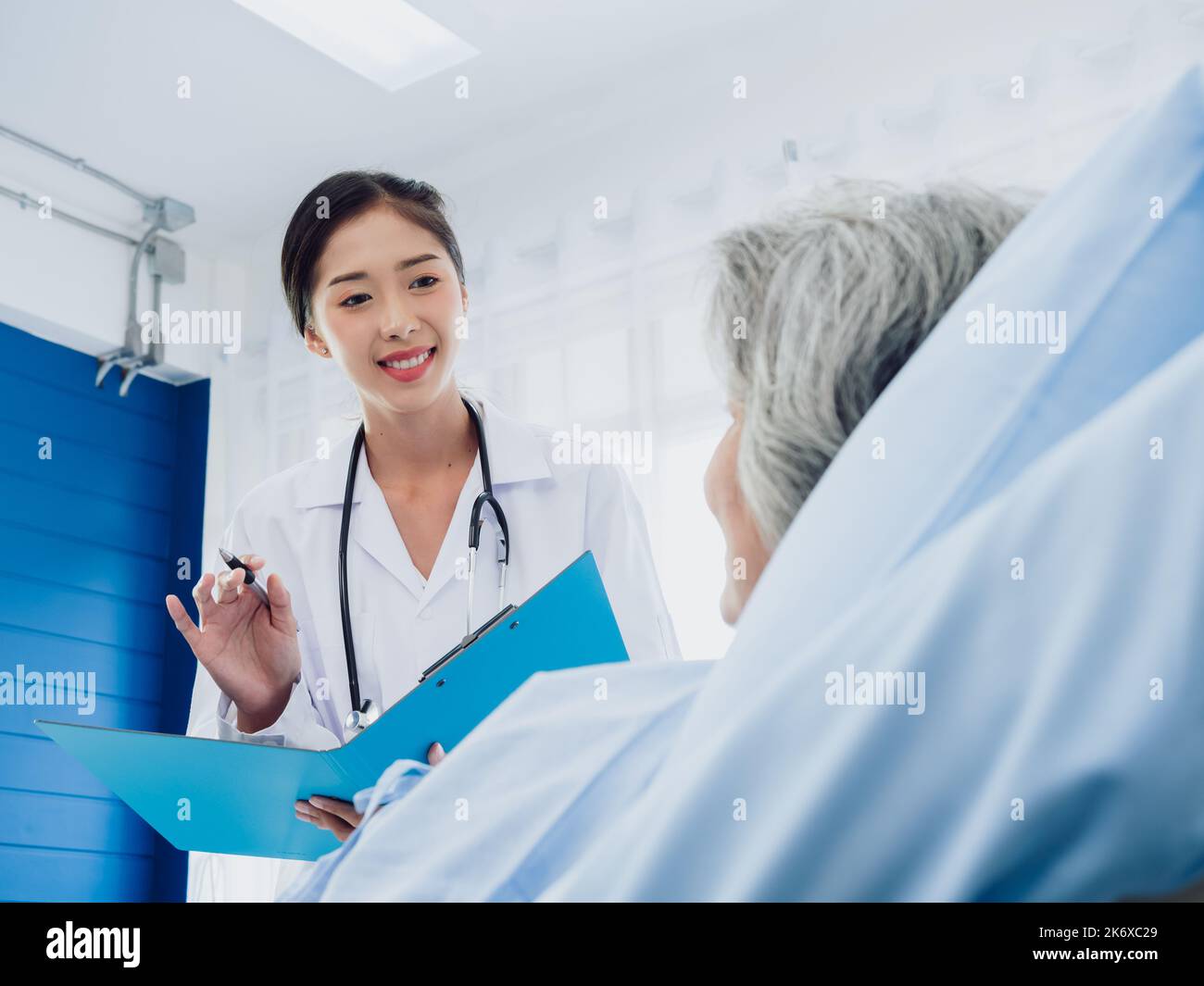 Young Asian female doctors visit senior woman patient in bed ...