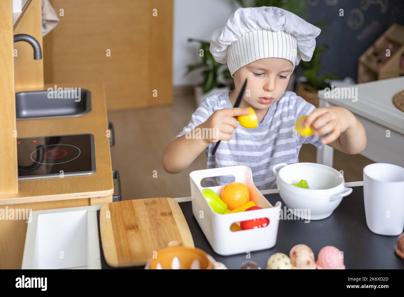 Mother and cute baby boy cooking food at childish kitchen playing chef ...