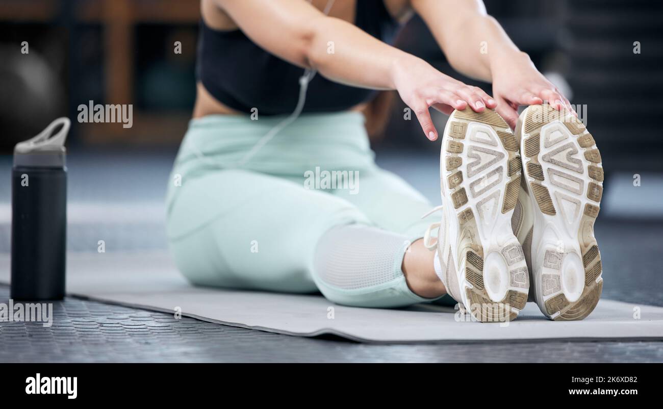 Have a good stretch then get going. a fit woman stretching in a gym ...