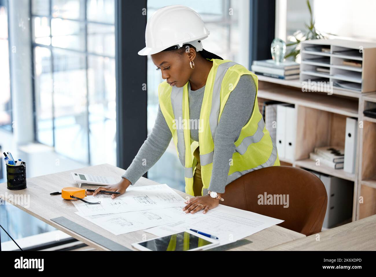 Making the necessary changes. a female engineer drawing up blueprints ...