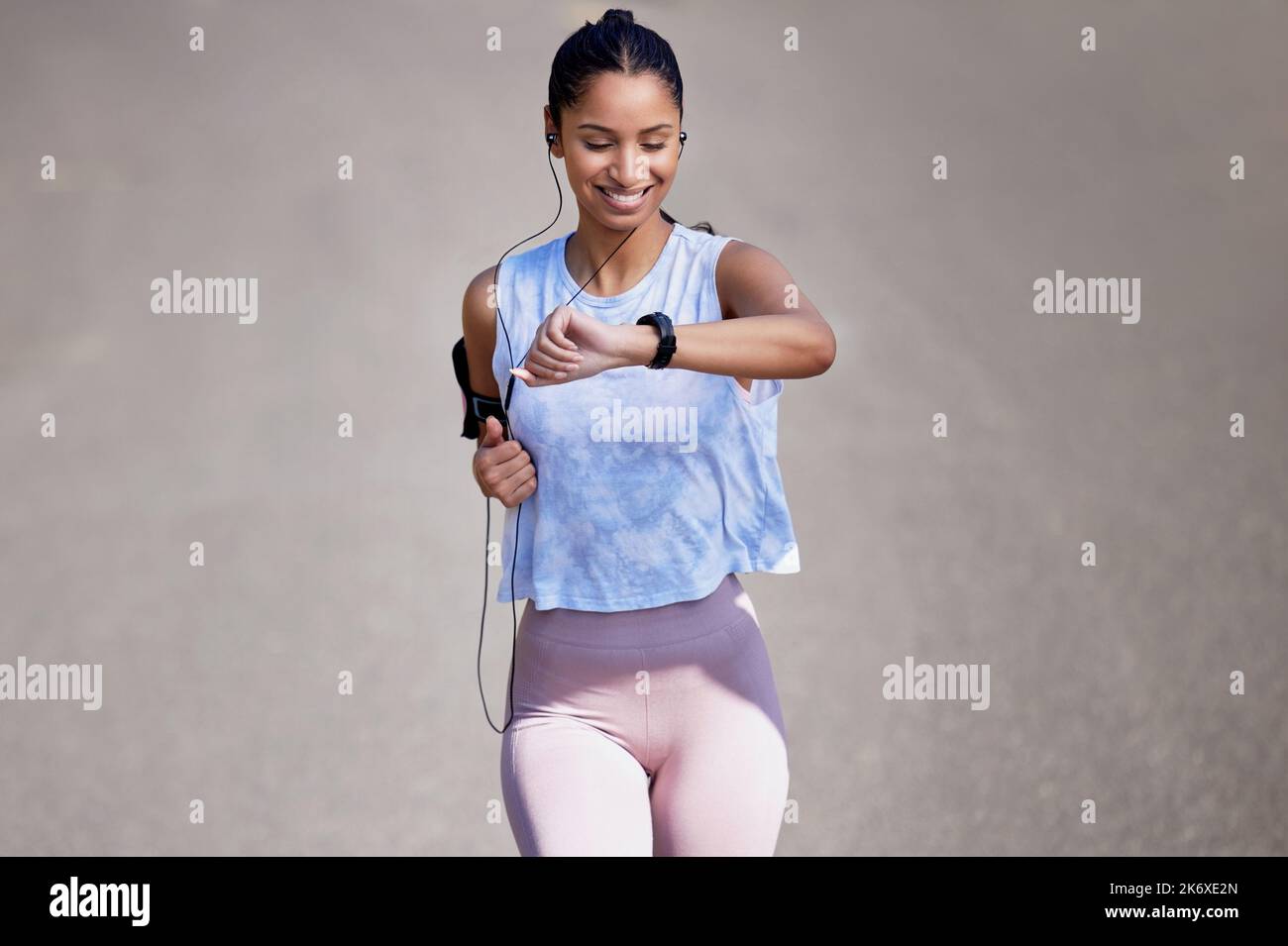 Im making great time. an attractive young female athlete checking her ...