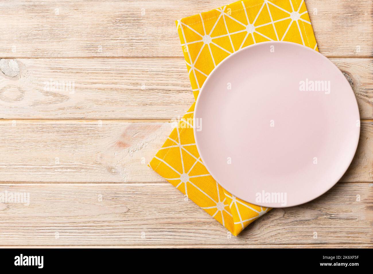 Top view on colored background empty round pink plate on tablecloth for ...
