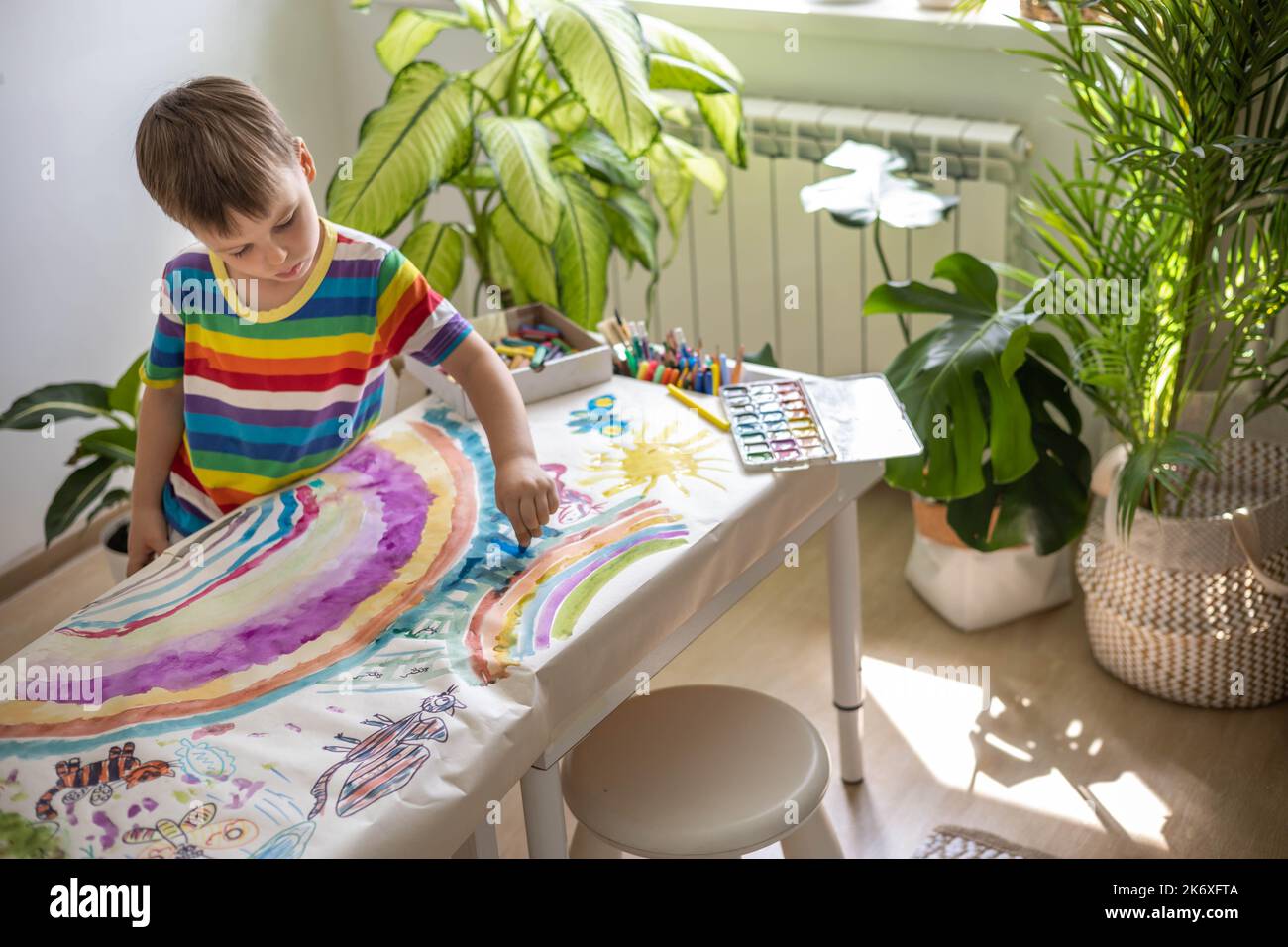 Confident cute male kid art drawing multicolored rainbow arch use ...