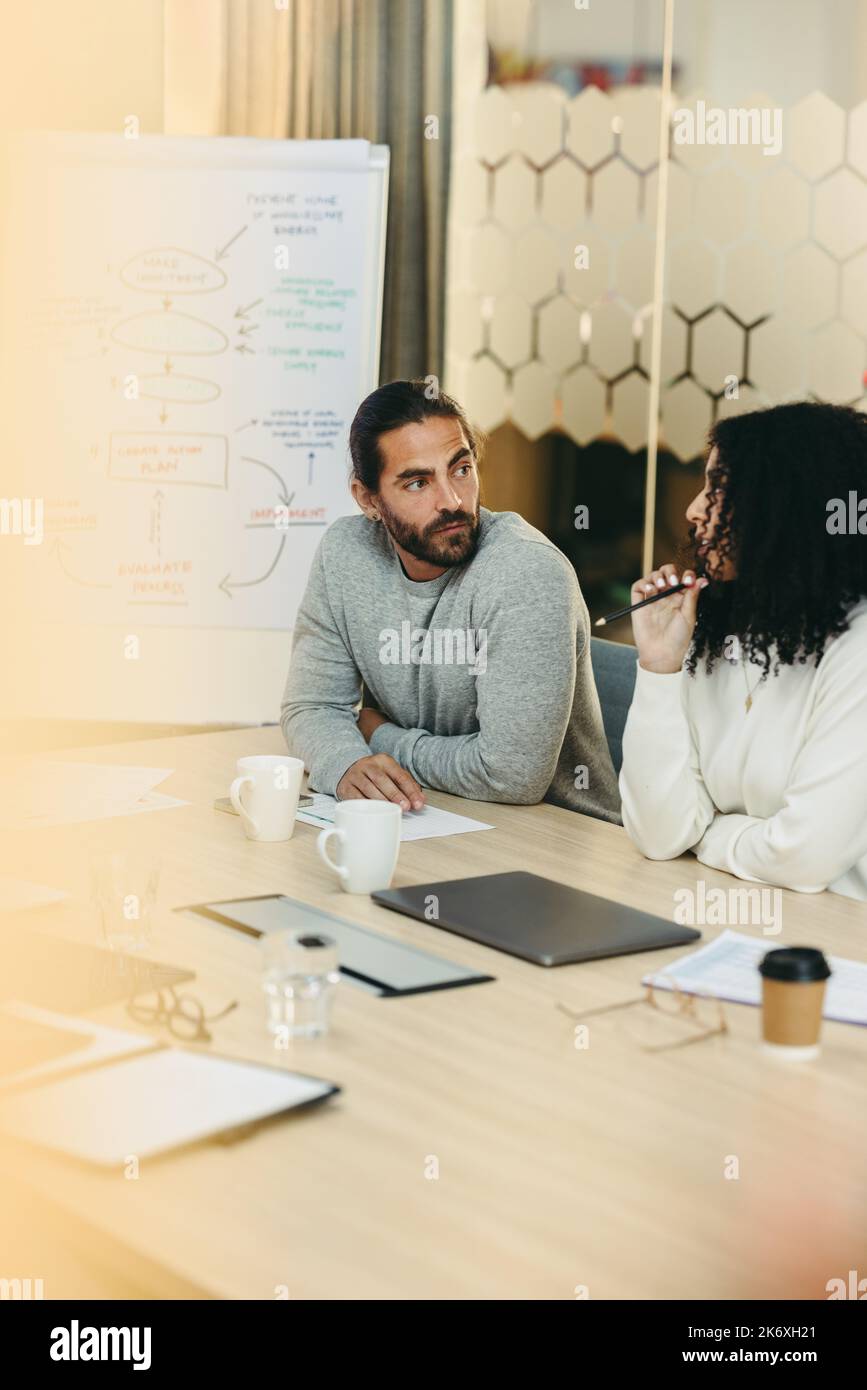 Two young businesspeople attending a boardroom meeting in a modern ...