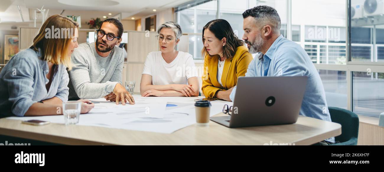 Multicultural designers sharing creative ideas during a meeting in a ...