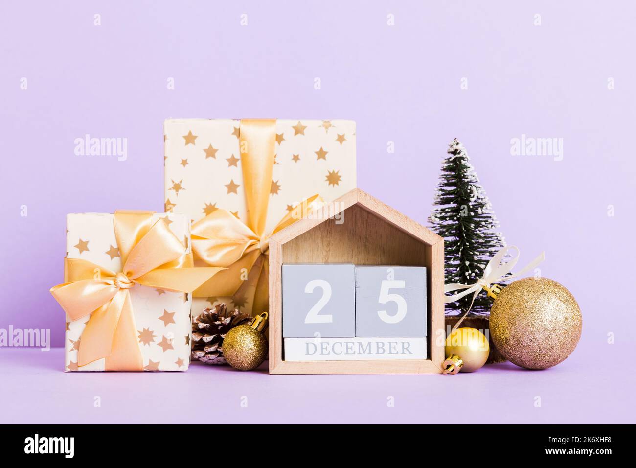 25 december. Christmas composition on colored background with a wooden ...