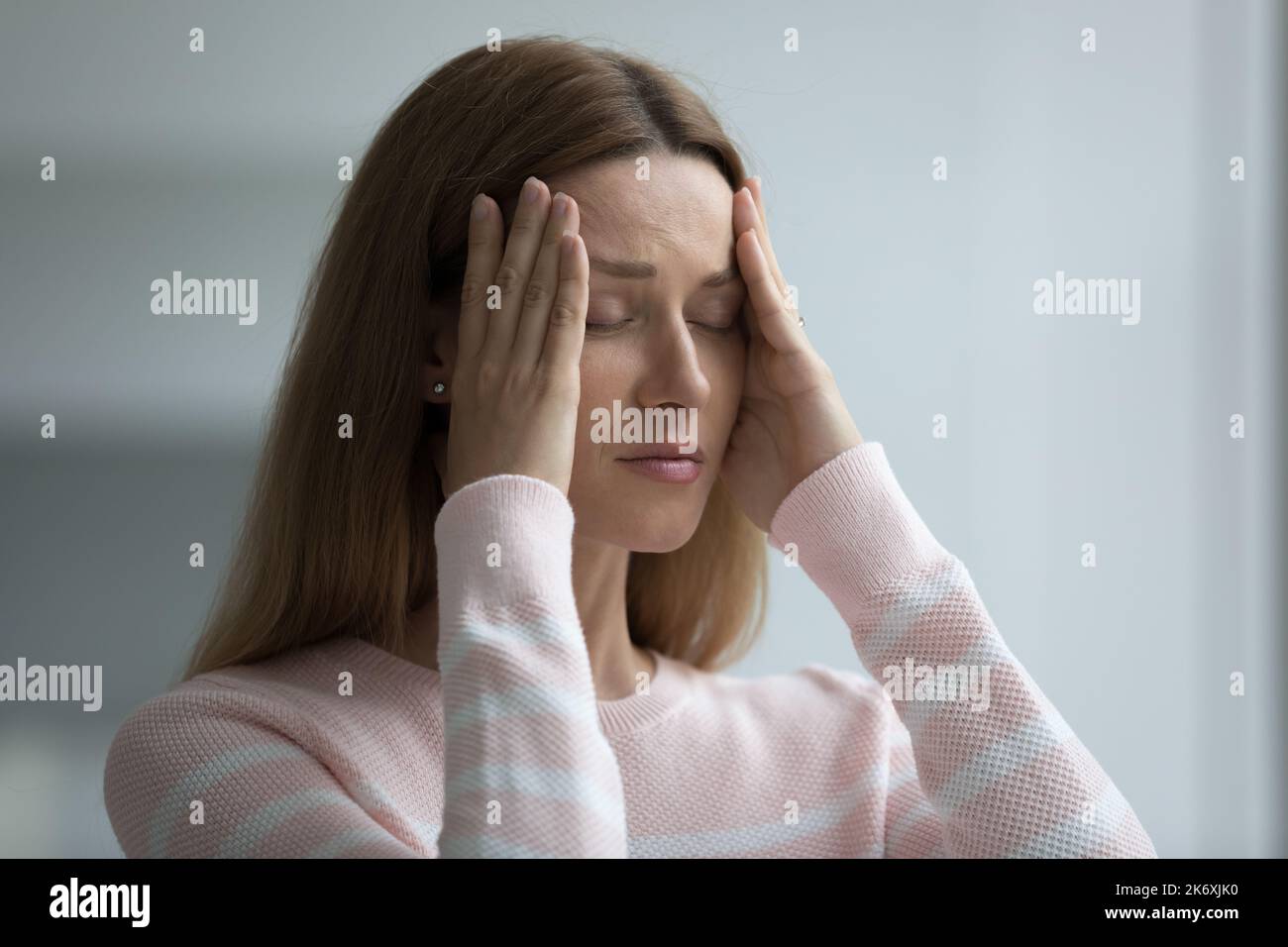 Woman suffers from intense headache, touch temples try relieving pain ...