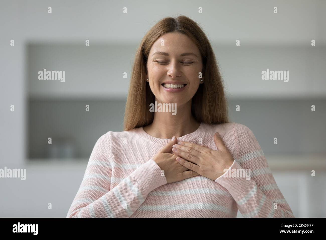 Headshot portrait young woman holding folded hands on chest Stock Photo ...