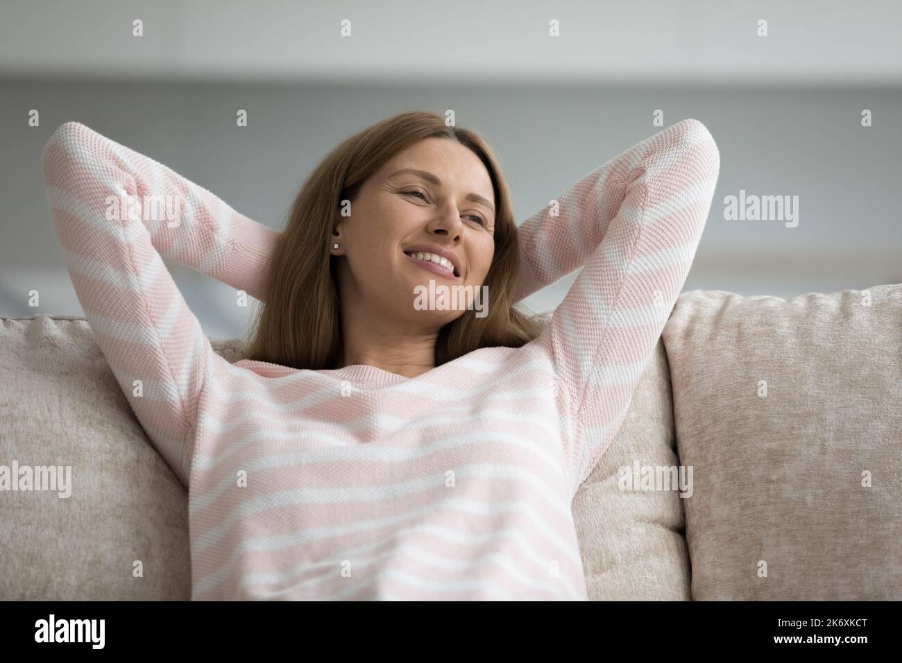 Beautiful woman resting alone seated on cozy sofa indoor Stock Photo ...