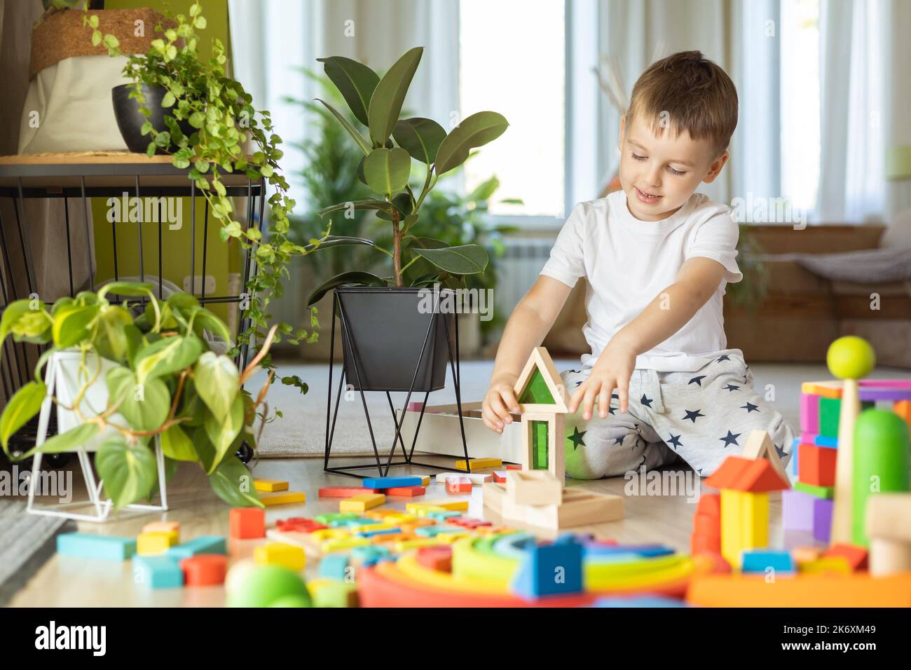 Confident male kid building fortress tower architecture and forest with ...