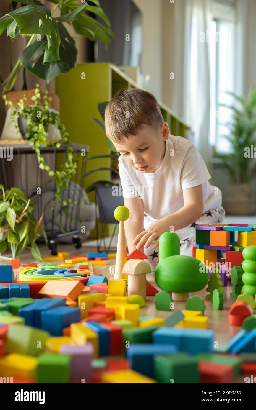 Confident male kid building fortress tower architecture and forest with ...