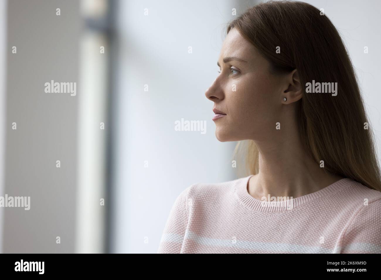 Side view sad woman staring into distance standing alone indoor Stock ...