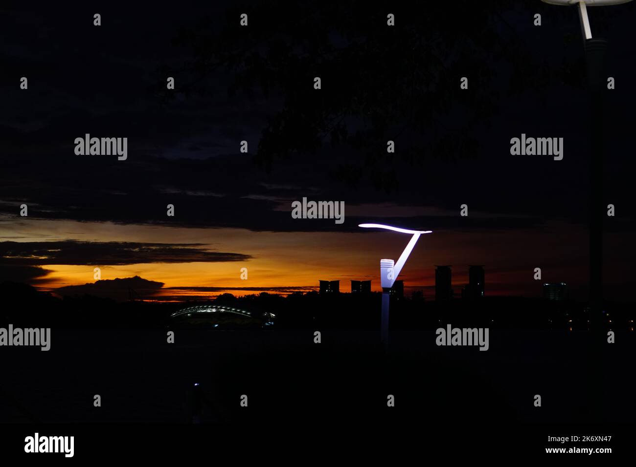 Street chandelier. Deep orange sunset with light poles receding into ...