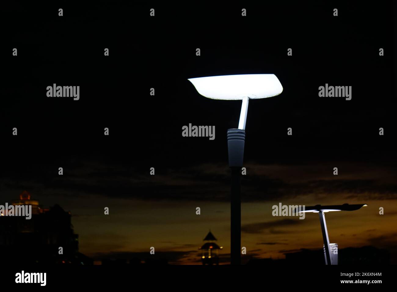 Street chandelier. Deep orange sunset with light poles receding into ...