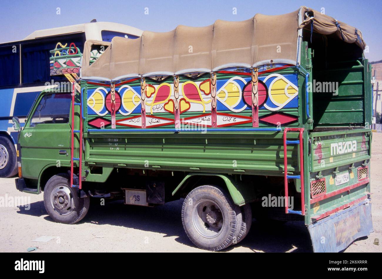 Brightly coloured Mazda truck with Arabic writing and tear in canvas ...