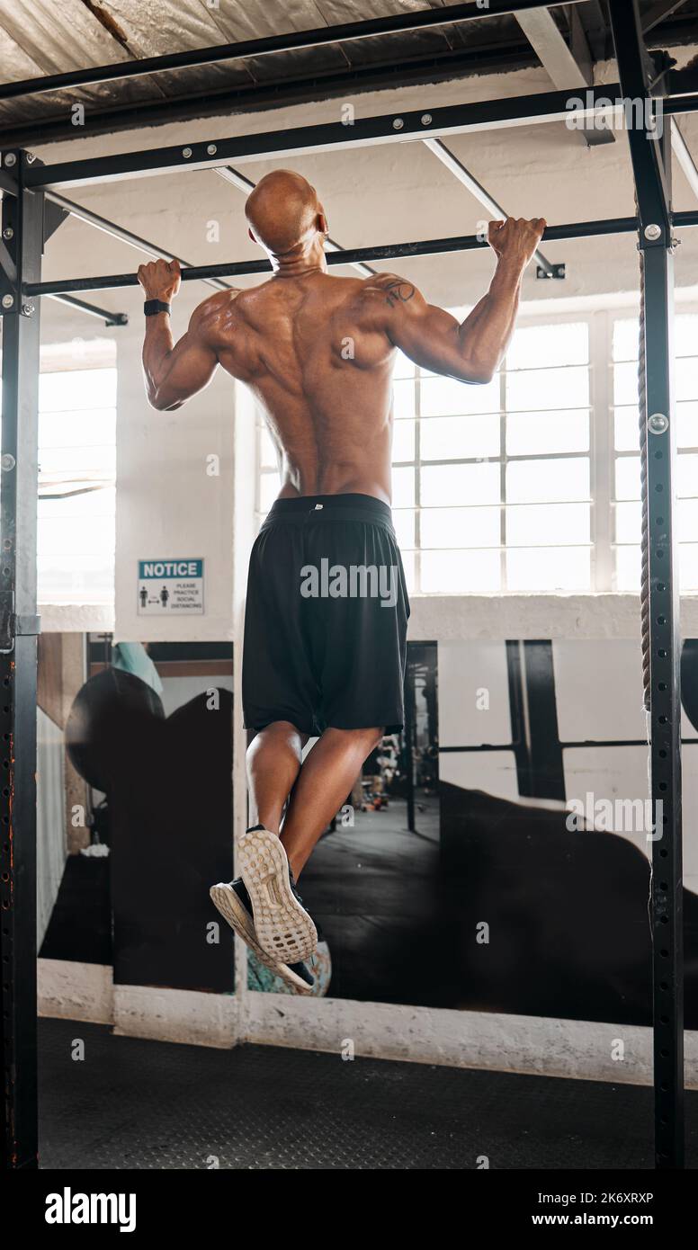 Focus on the body you aim to have. a man completing pull ups in his gym ...