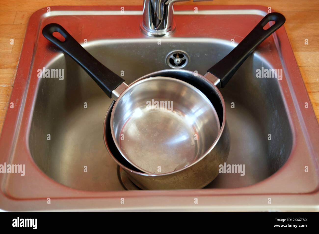 stainless steel pans in kitchen sink - top view Stock Photo - Alamy