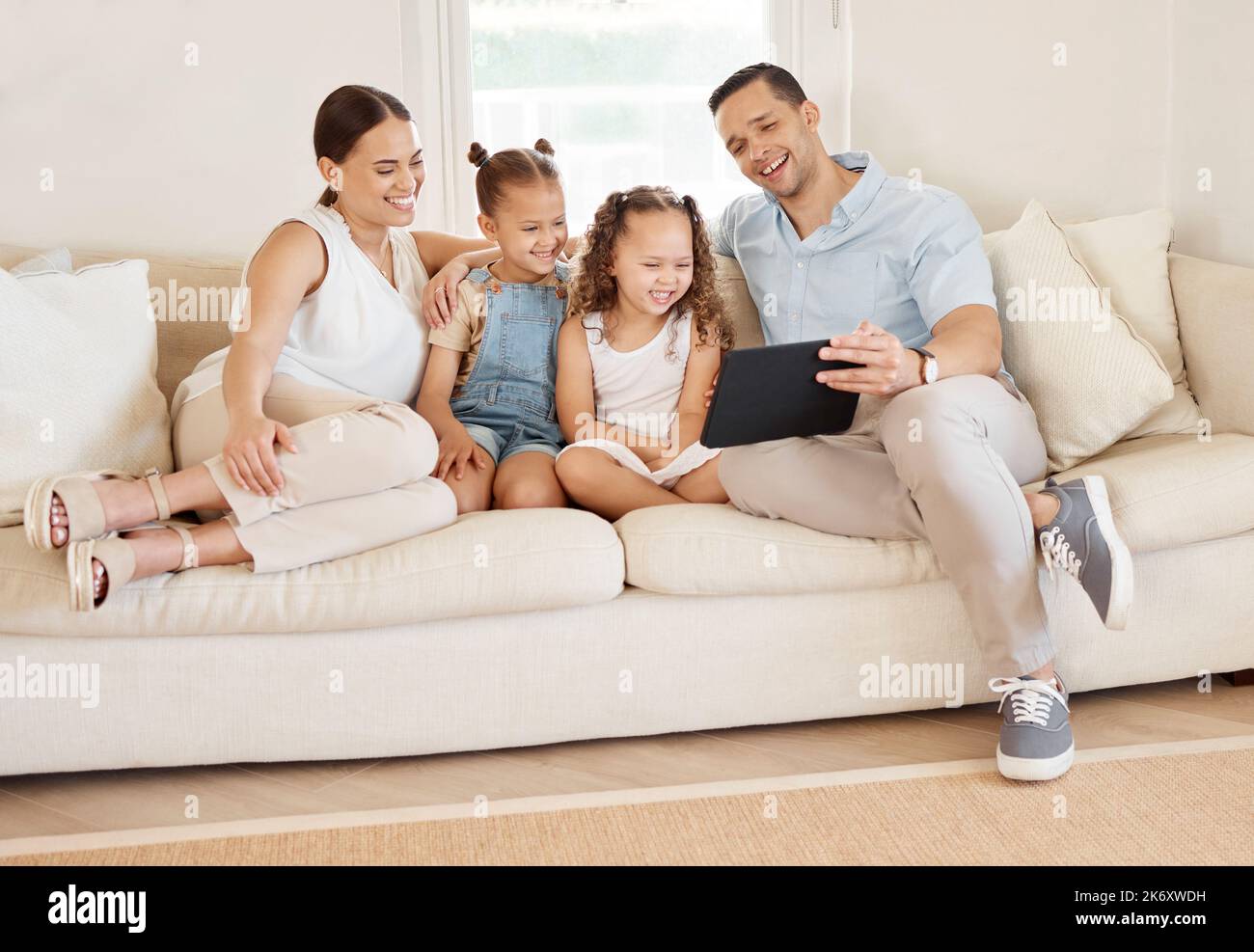 We love us some family screen time. a young family sitting together ...