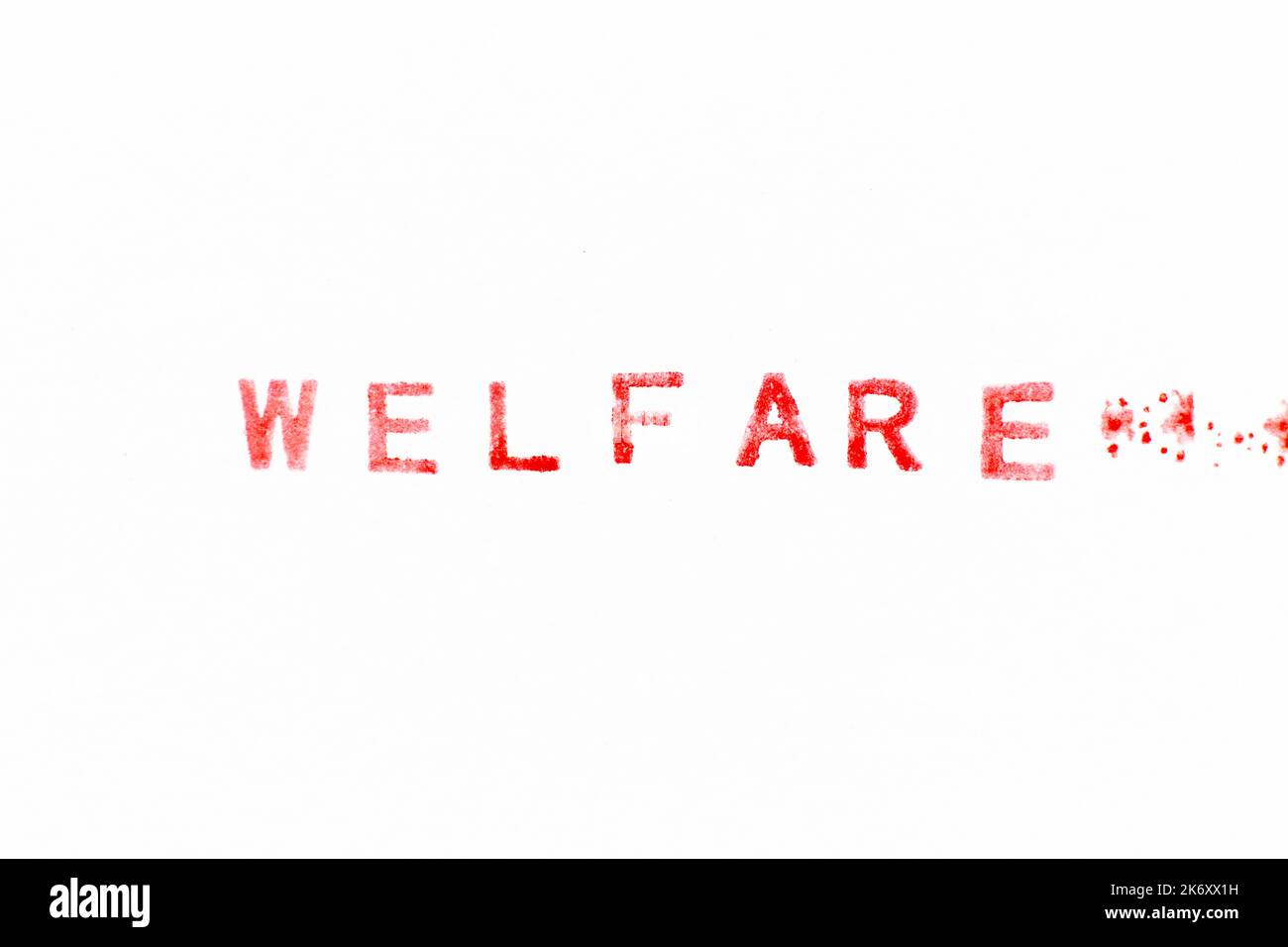 Red color ink rubber stamp in word welfare on white paper background ...