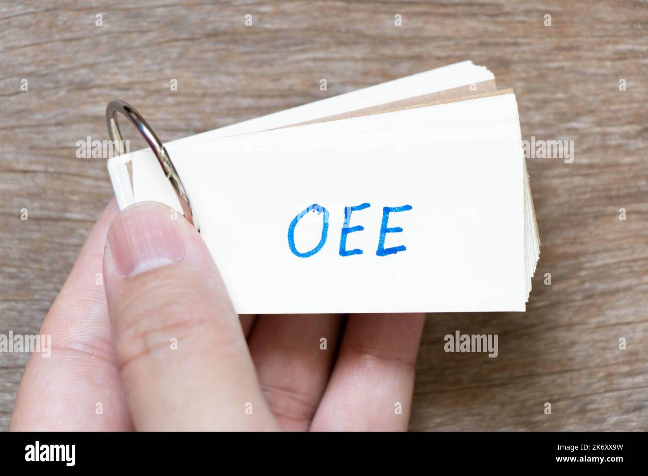 Hand hold flash card with handwriting in word OEE (abbreviation of ...