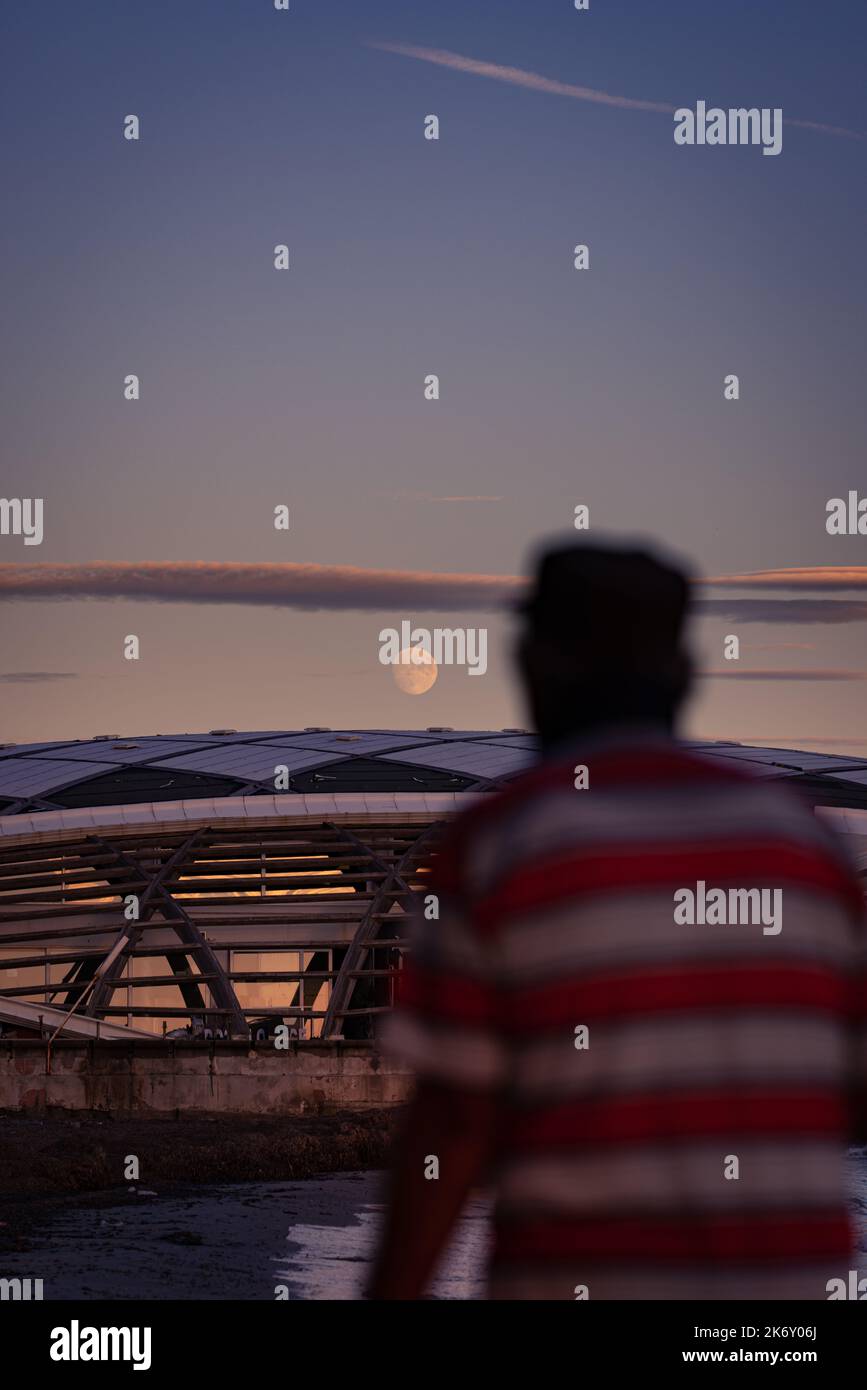 Man watching moon rise over building at sunset in Durres, Albania Stock ...