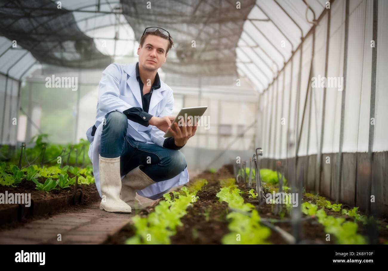 Portrait of handsome agricultural researcher holding tablet while ...