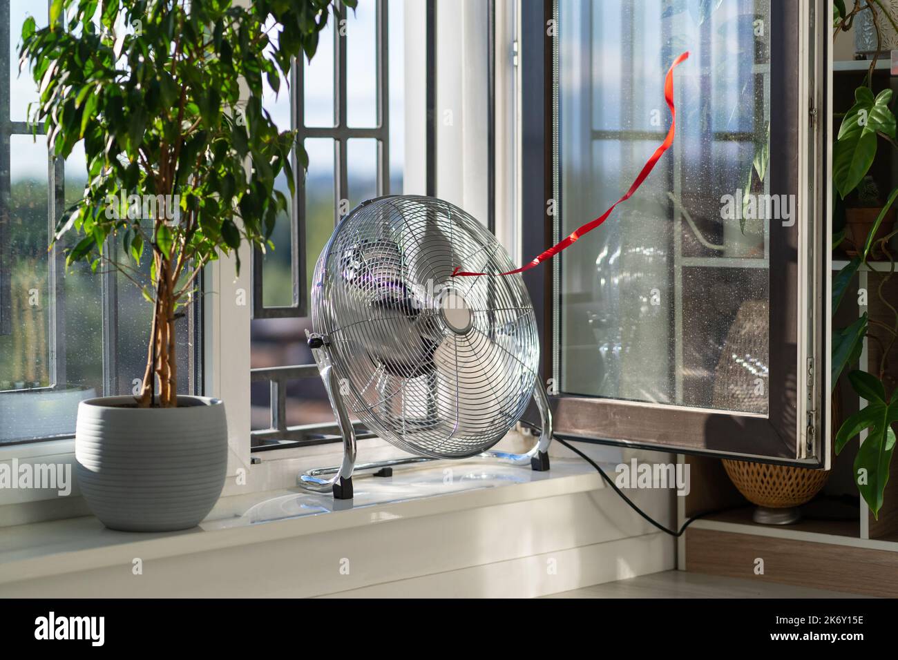 Electric fan with red wriggle ribbon designed to cool air and supply ...