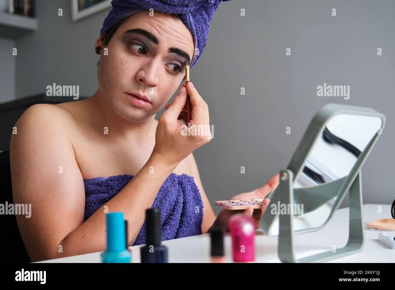 Young transgender man applying eyeshadow Stock Photo - Alamy