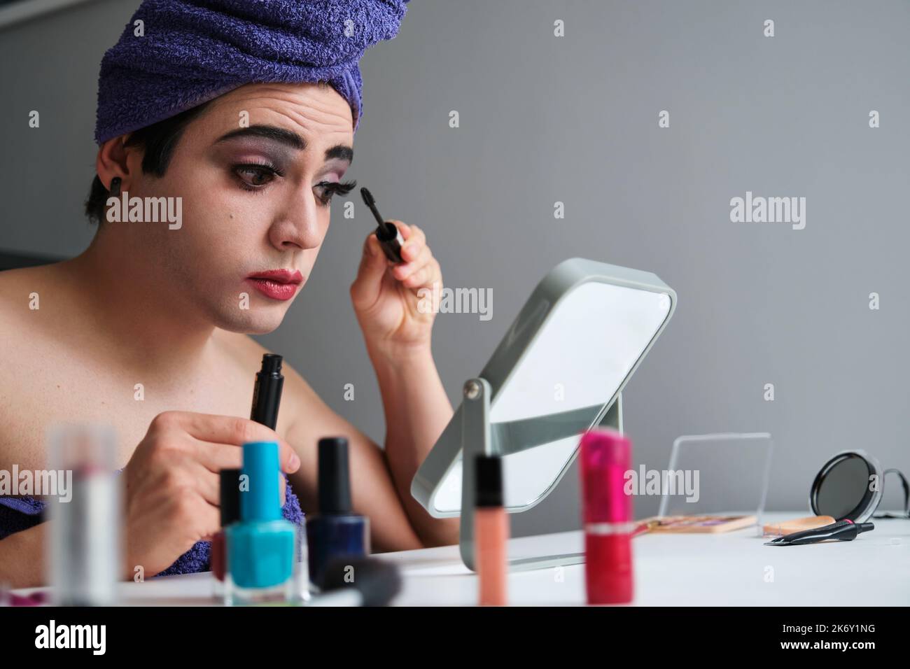 Young transgender man applying eye mascara Stock Photo - Alamy