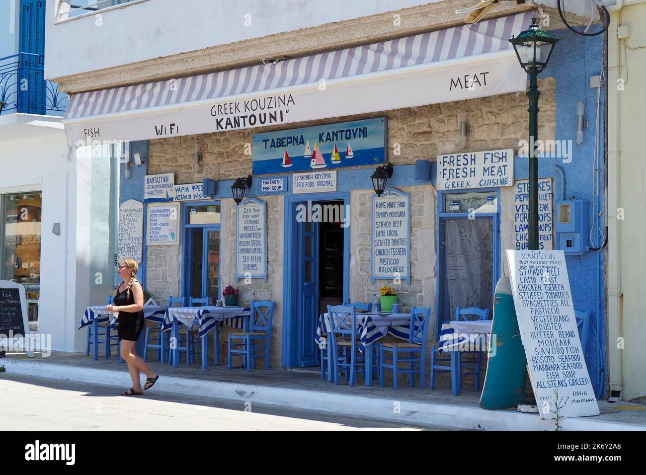 waitress crosses road outside Kantouni, traditional Greek Taverna, Vathi,Ithaca,Greece,Europe ...
