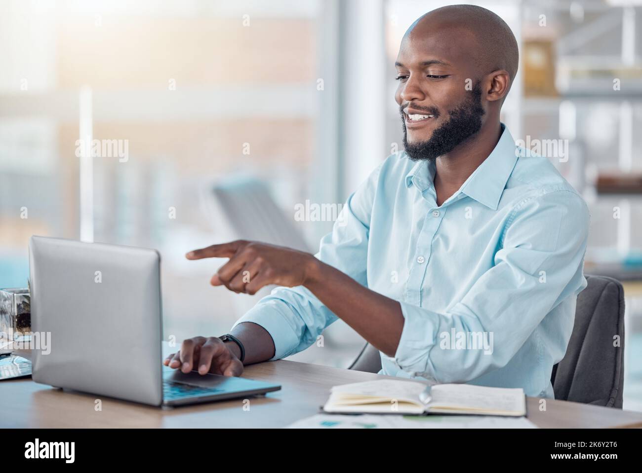 Youre not going to believe this. a young businessman working on his laptop Stock Photo - Alamy