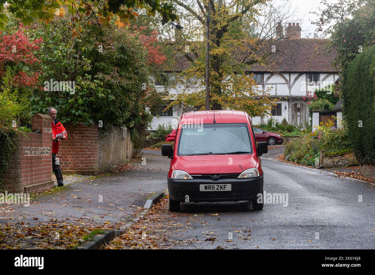 Postman with red royal mail van delivering letters in Micheldever ...